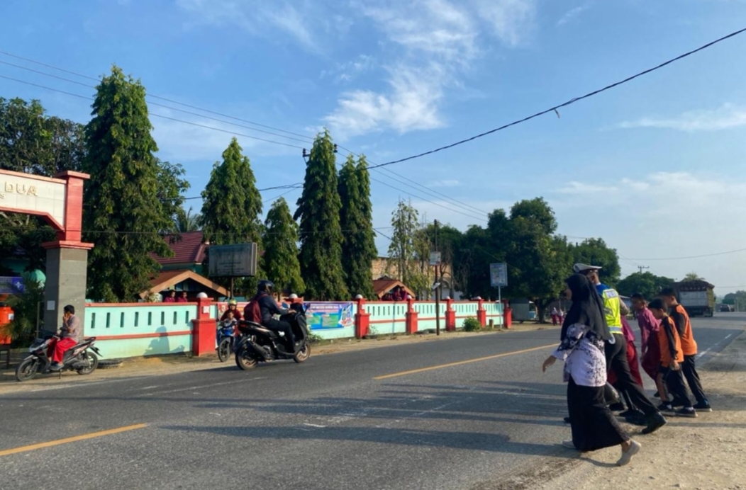 Gatur Lalin Pagi, Polisi Ini Bantu Anak Sekolah Menyebrang Jalan